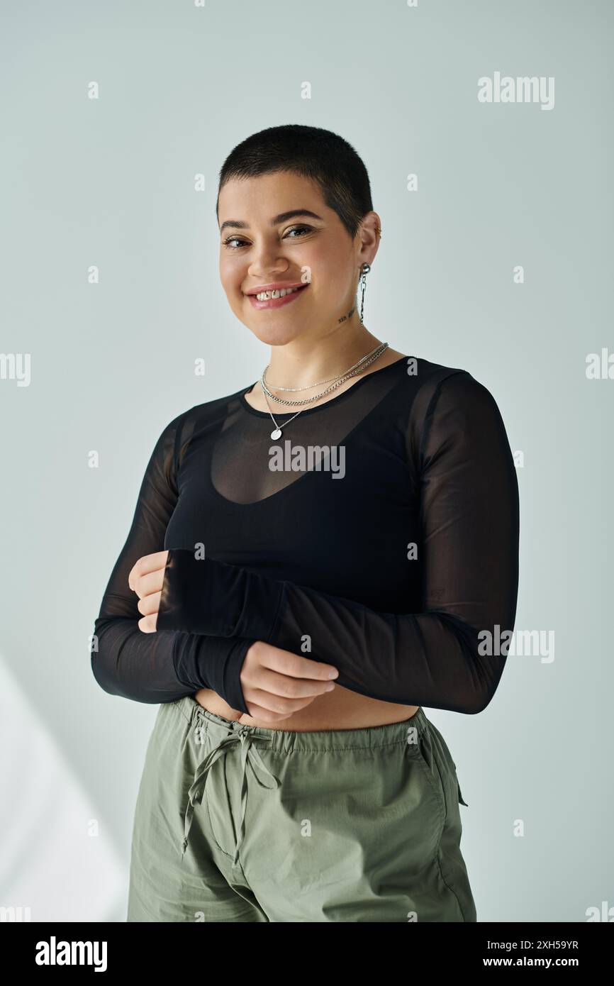 A young woman with short hair strikes a pose in trendy casual clothing ...
