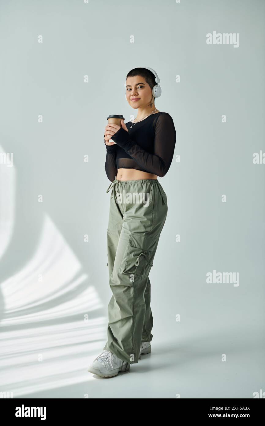 A stylish young woman with short hair strikes a confident pose in front ...
