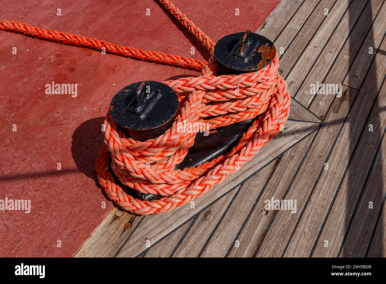 A fragment of the ship and mooring bollard on a wooden deck with red ...