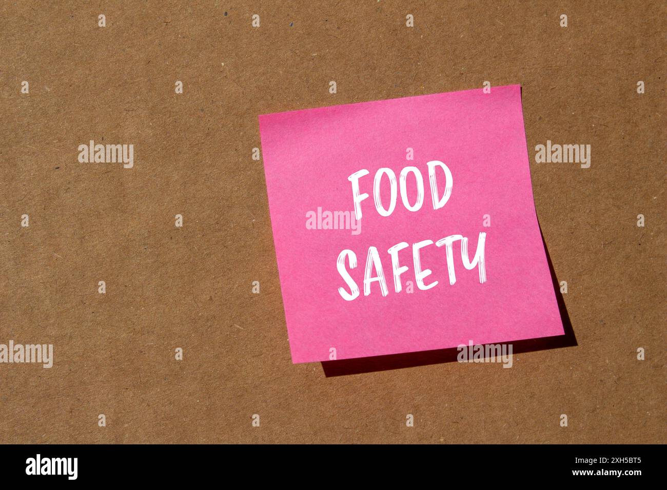 Food safety message written on pink paper with cardboard background ...