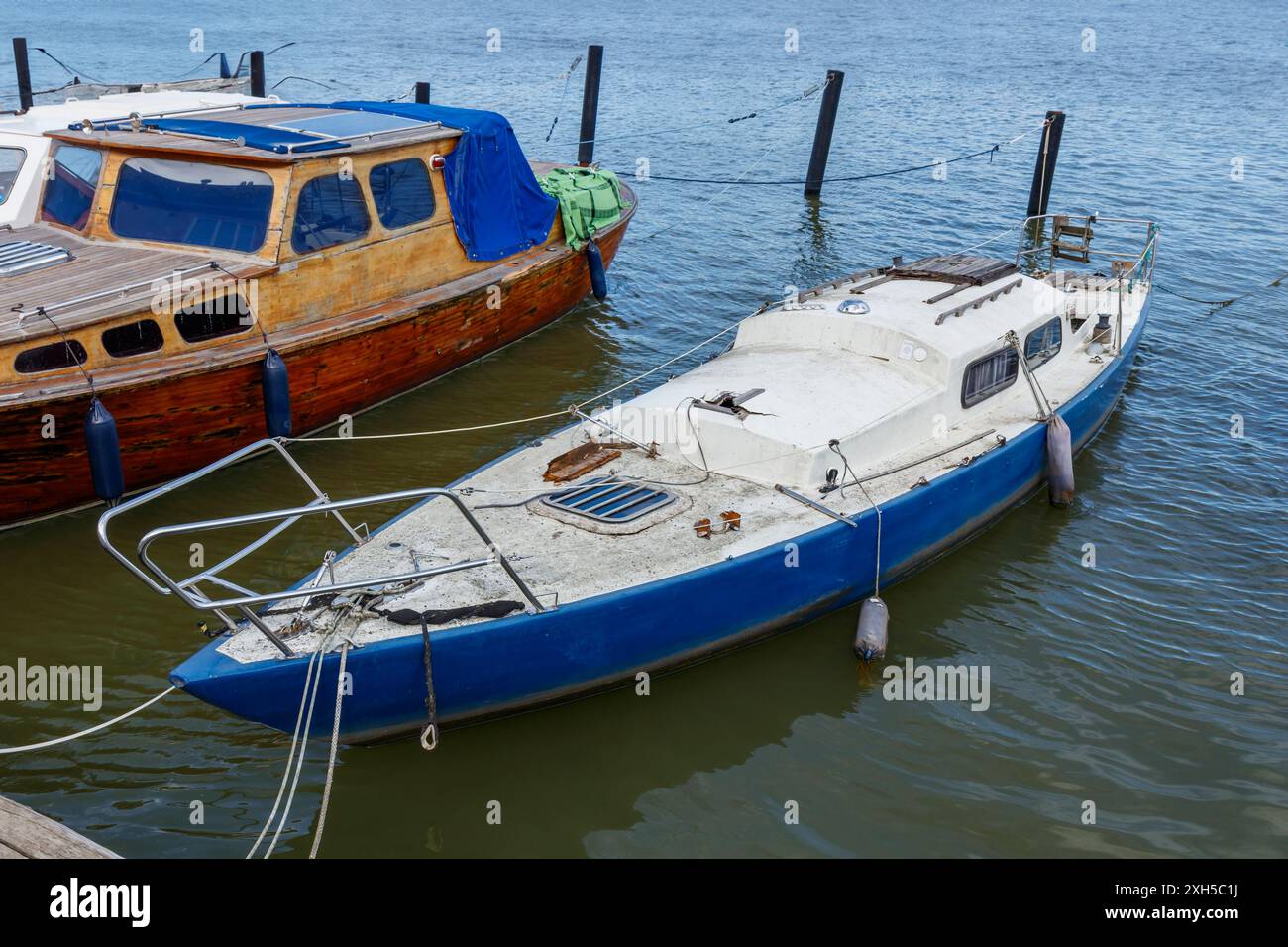 Close up of an old, dirty, crushed neglected abandoned sailing boat in ...