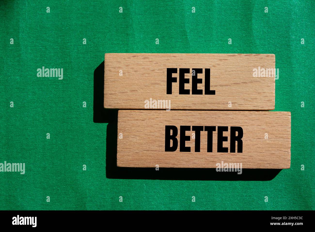 Feel better message written on wooden blocks with green background ...