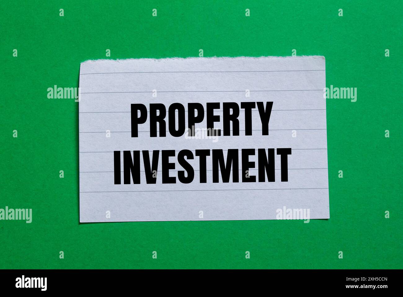 Property investment message written on ripped torn paper piece with ...
