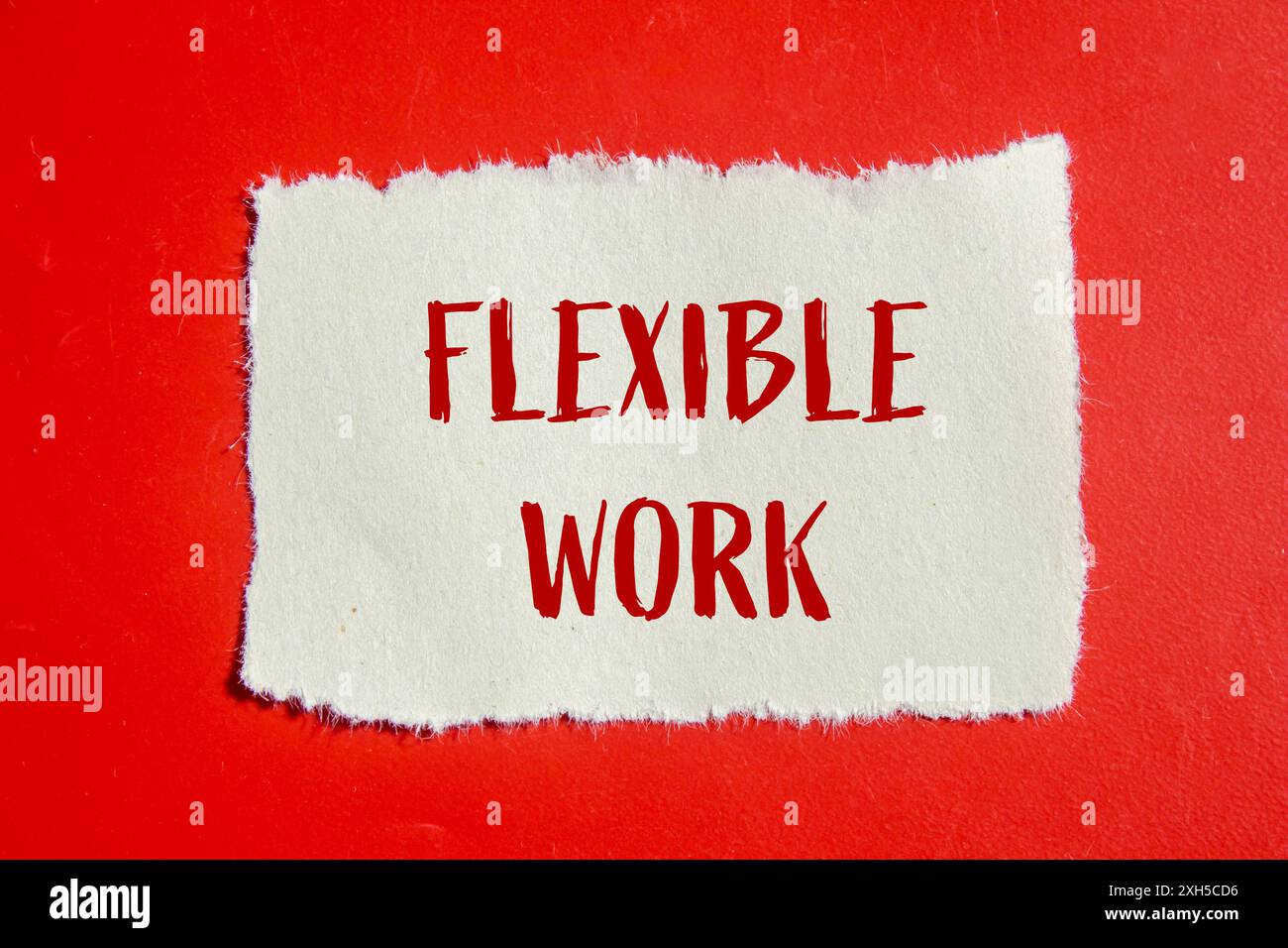 Flexible work message written on ripped torn paper piece with red background. Conceptual ...