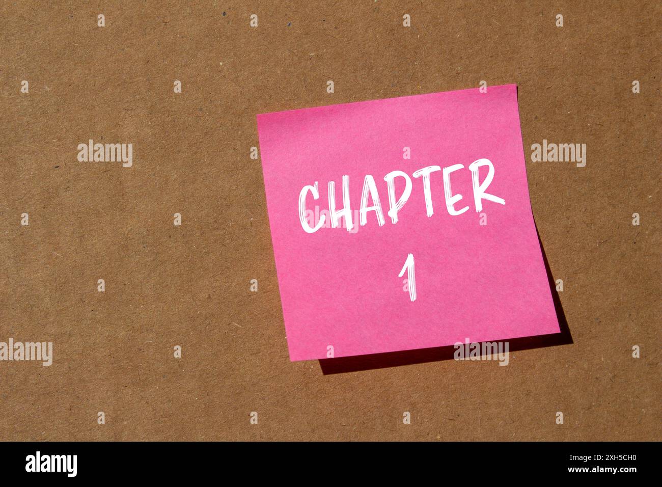 Chapter 1 message written on pink paper with cardboard background ...