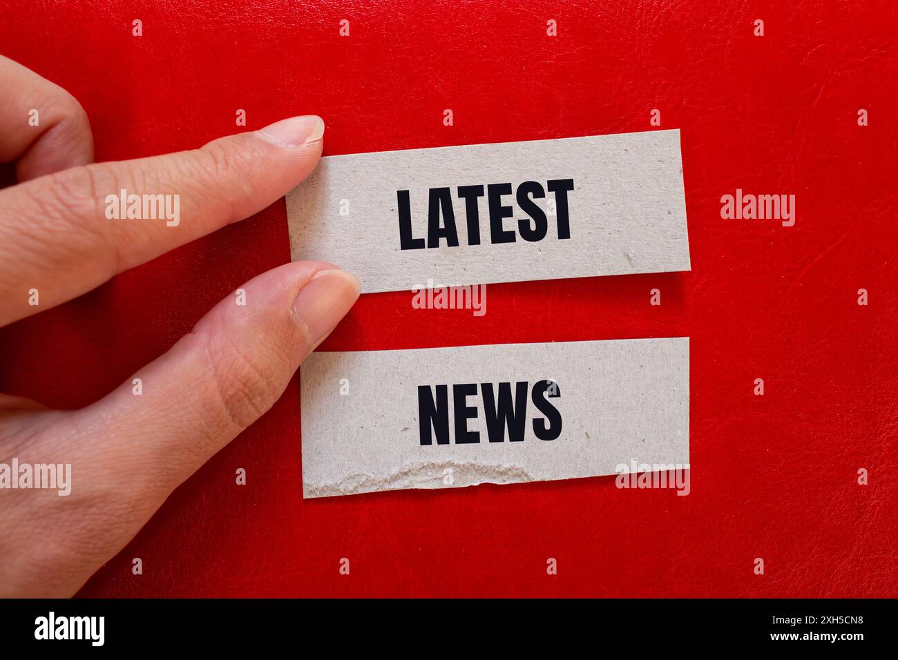 Latest news message written on paper pieces with red background ...