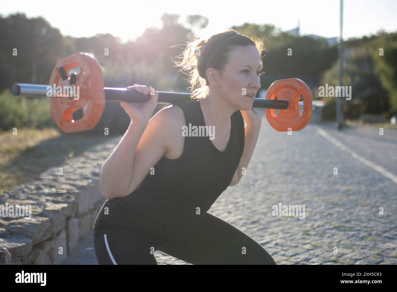 A woman is lifting a heavy weight bar Stock Photo - Alamy