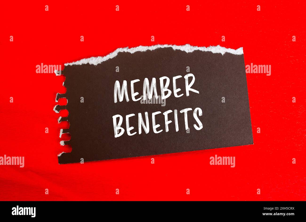 Member benefits message written on ripped torn black paper piece with red background. Conceptual ...