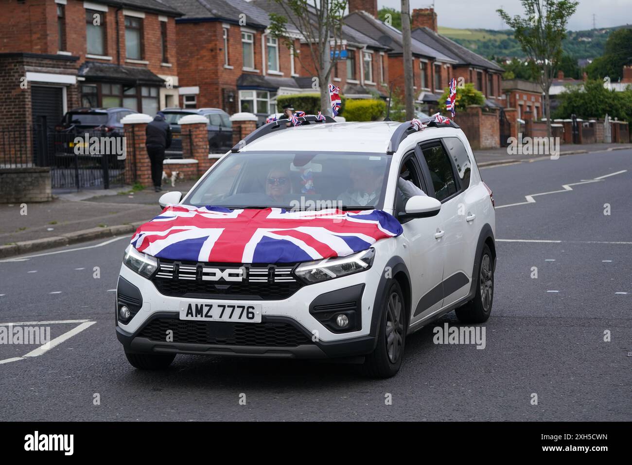 A car with Union flags on drives down the Crumlin Road in Belfast ahead ...