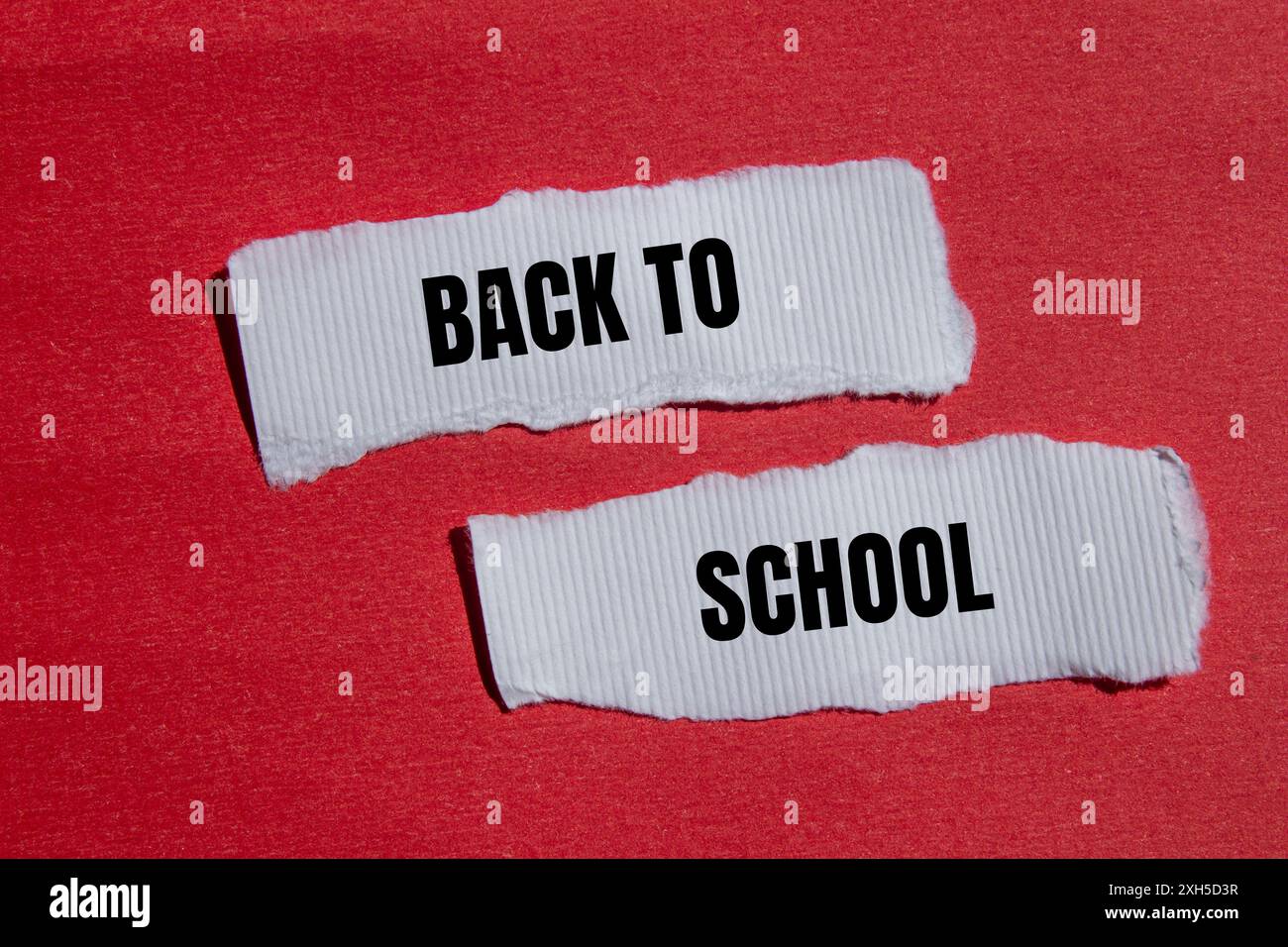 Back to school message written on ripped torn white paper with red ...