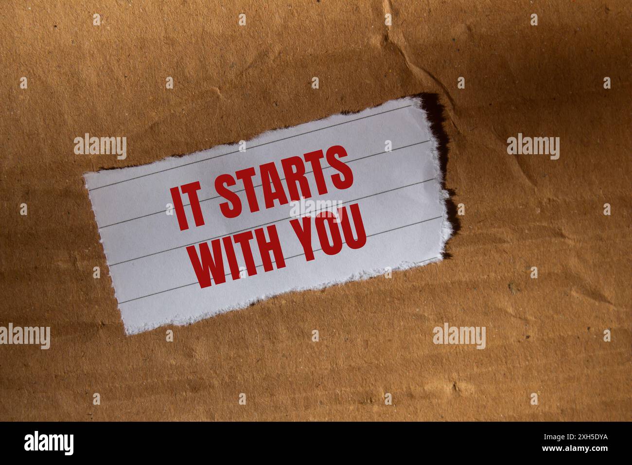 It starts with you message written on ripped torn white paper piece with cardboard background ...