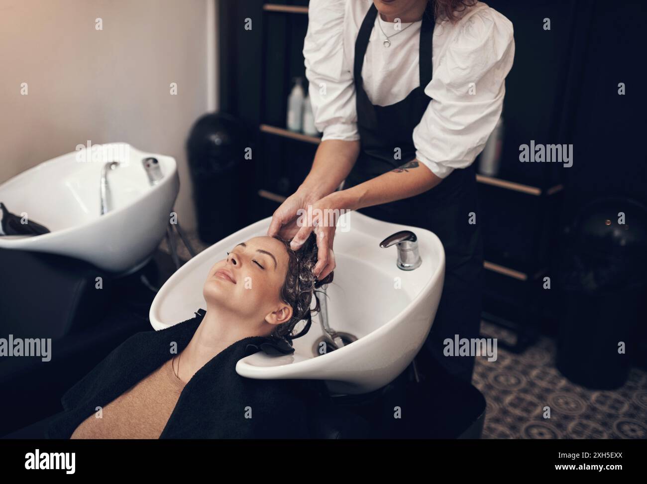 Hairdresser, soap and water for client hair, salon and treatment with ...