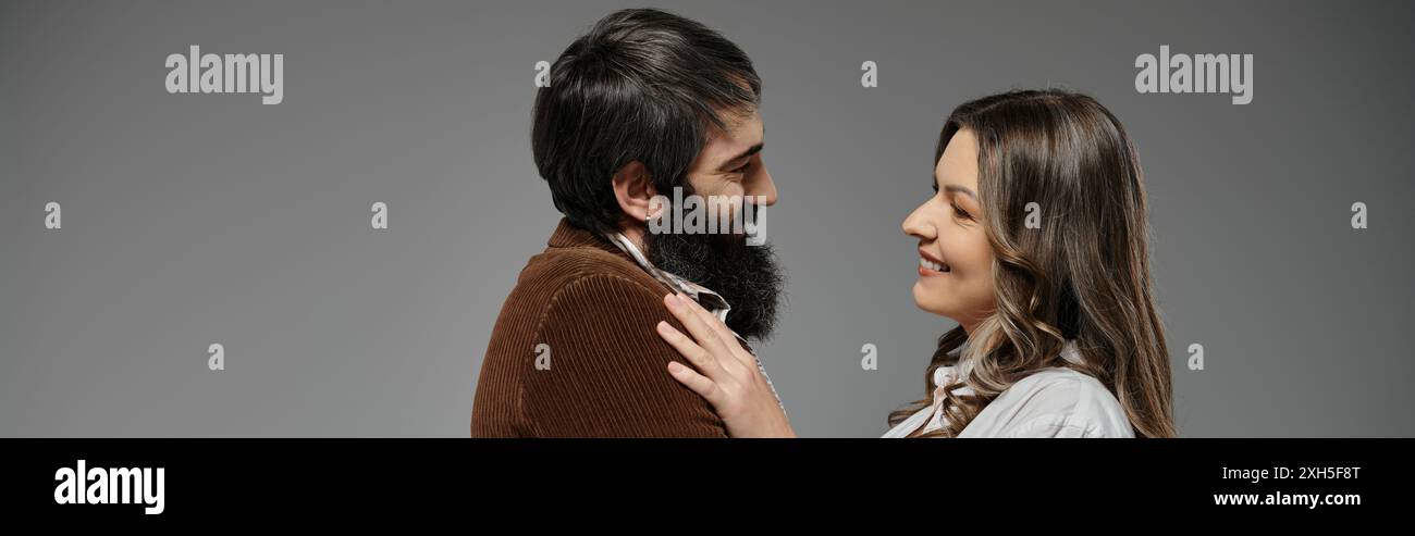 A couple in sophisticated attire gaze lovingly at each other, creating ...