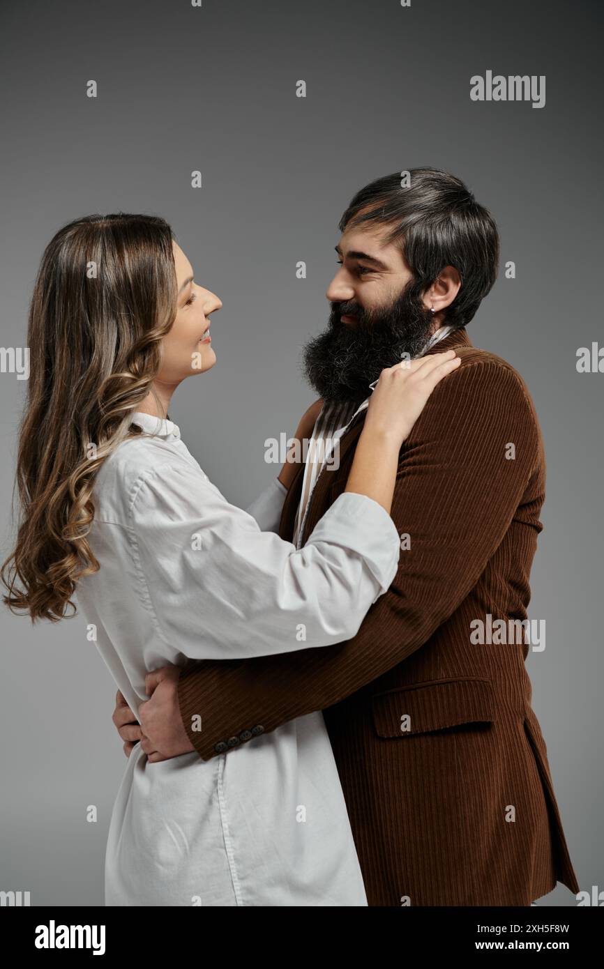 A loving couple, dressed in sophisticated attire, embrace each other ...