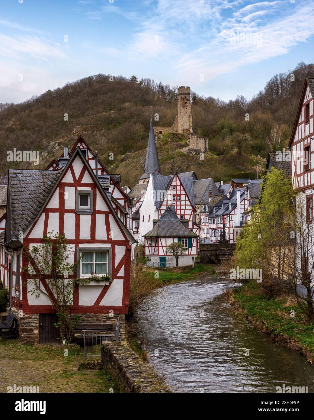 Charming half-timbered houses by a river with a medieval castle on a ...