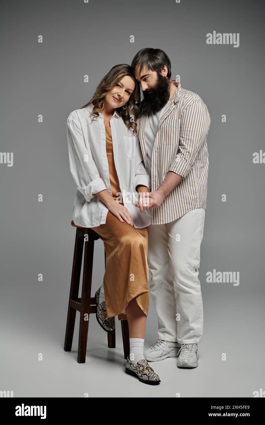 A loving couple poses together in a studio setting, showcasing their ...