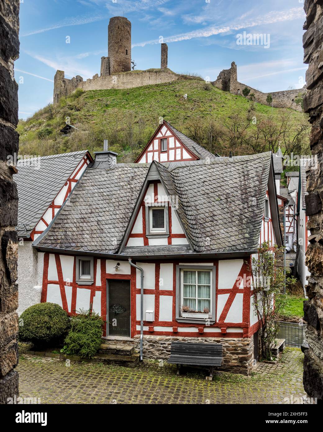 Charming half-timbered houses by a river with a medieval castle on a ...