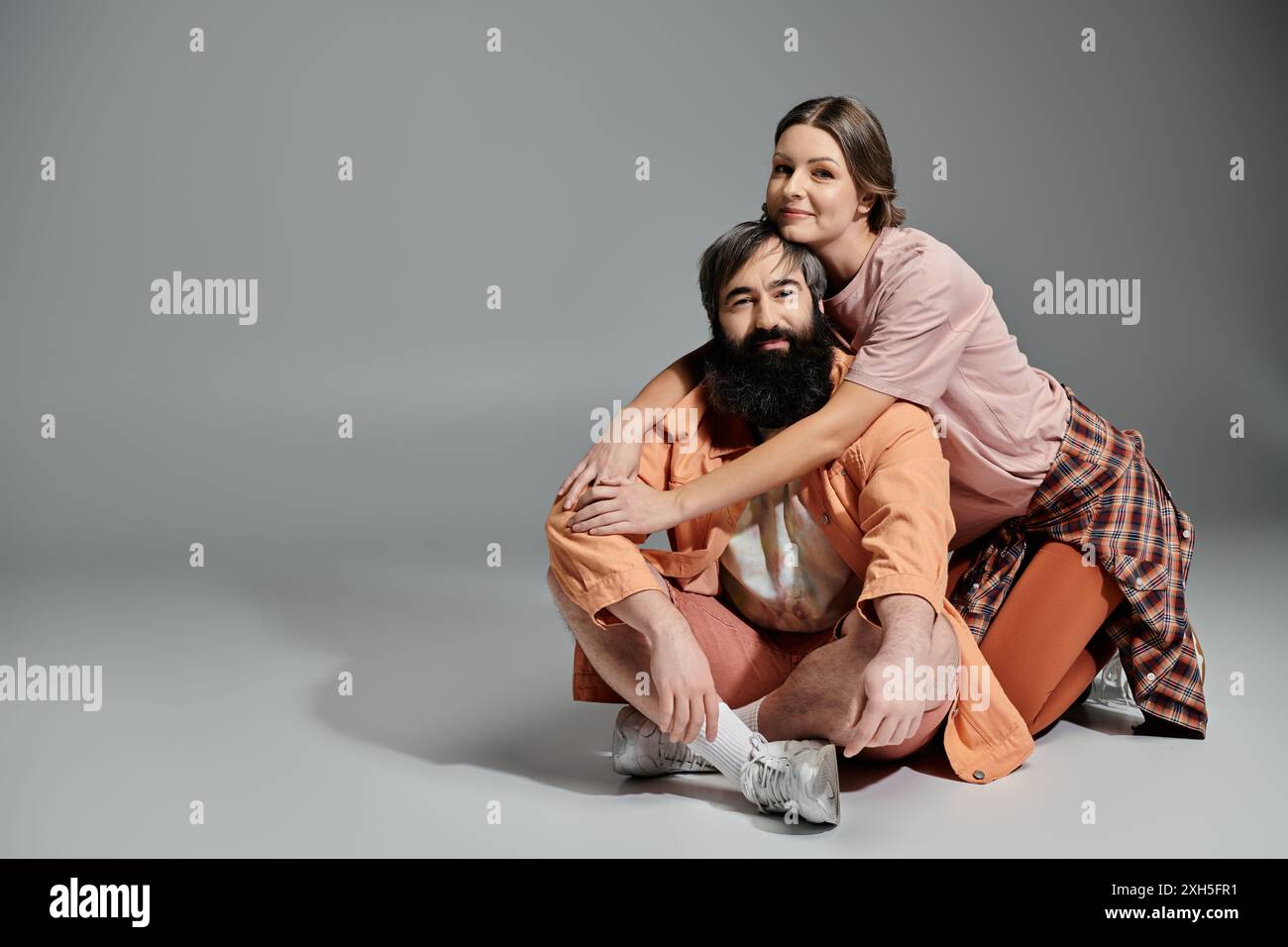 A loving couple, dressed in sophisticated attire, poses together in a ...