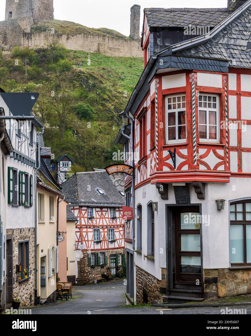 Charming half-timbered houses by a river with a medieval castle on a ...