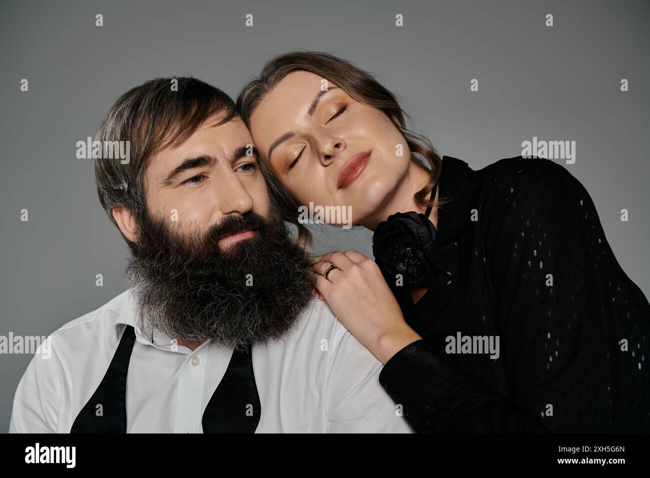 A loving couple poses together in sophisticated attire, capturing a ...