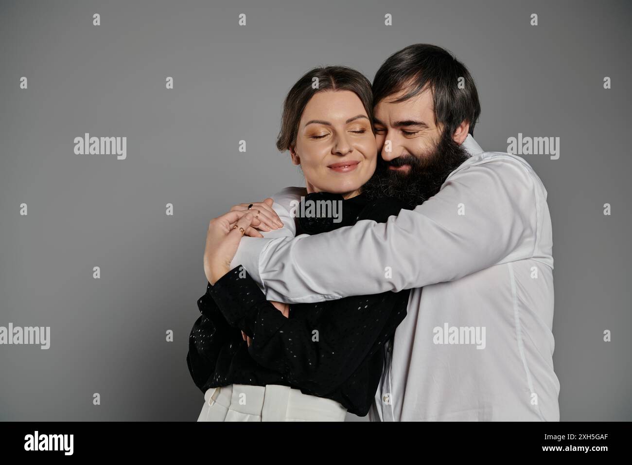 A loving couple in sophisticated attire poses for a portrait, embracing ...