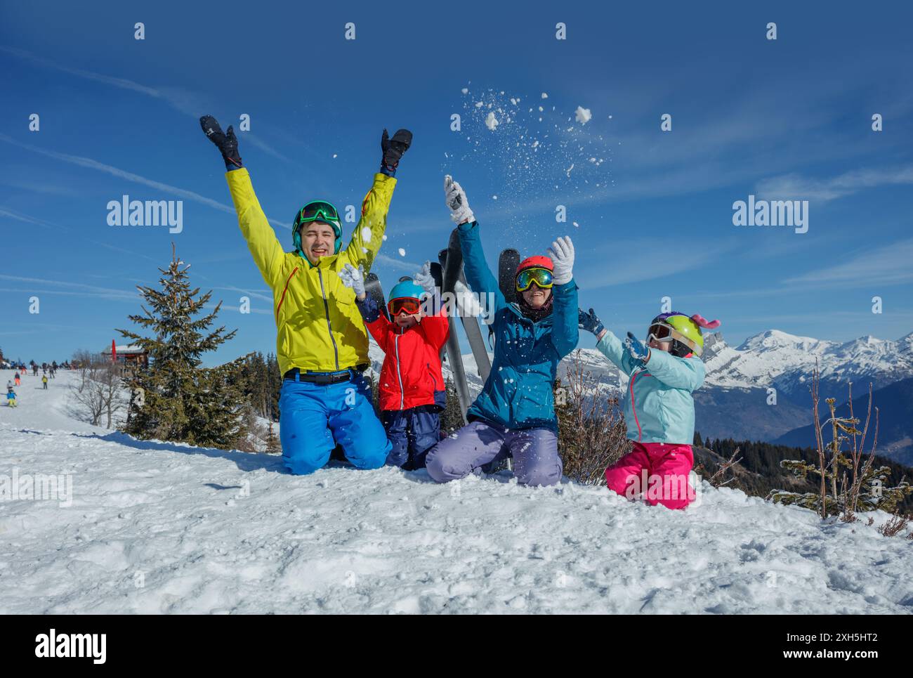 Parent with kids in colorful outfits have fun play throw snow Stock ...