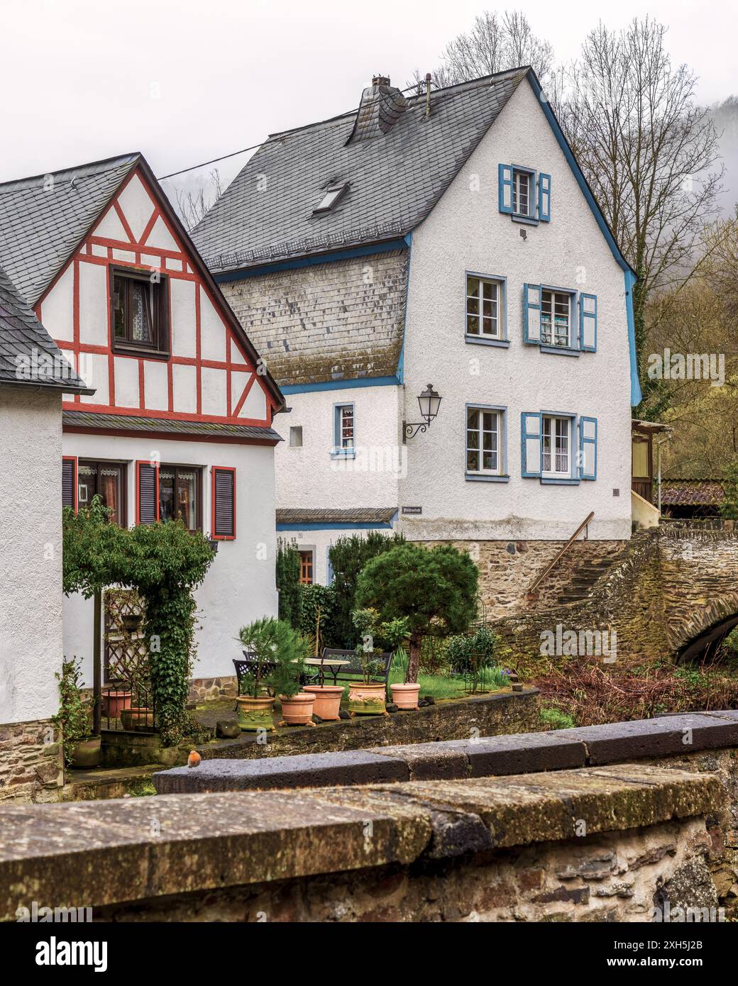 Charming half-timbered houses by a river with a medieval castle on a ...