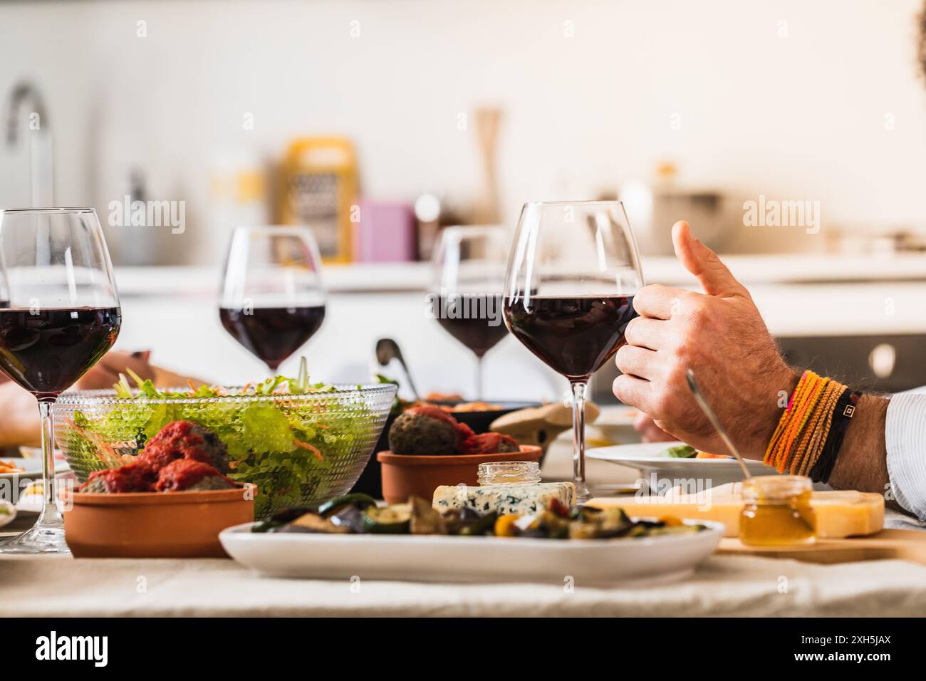 Man giving thumbs up approving delicious food and wine during dinner ...