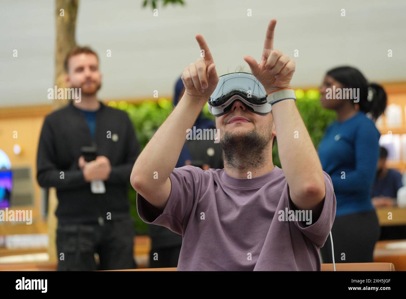 A customer tries the new Apple Vision Pro in Apple's flagship store in ...