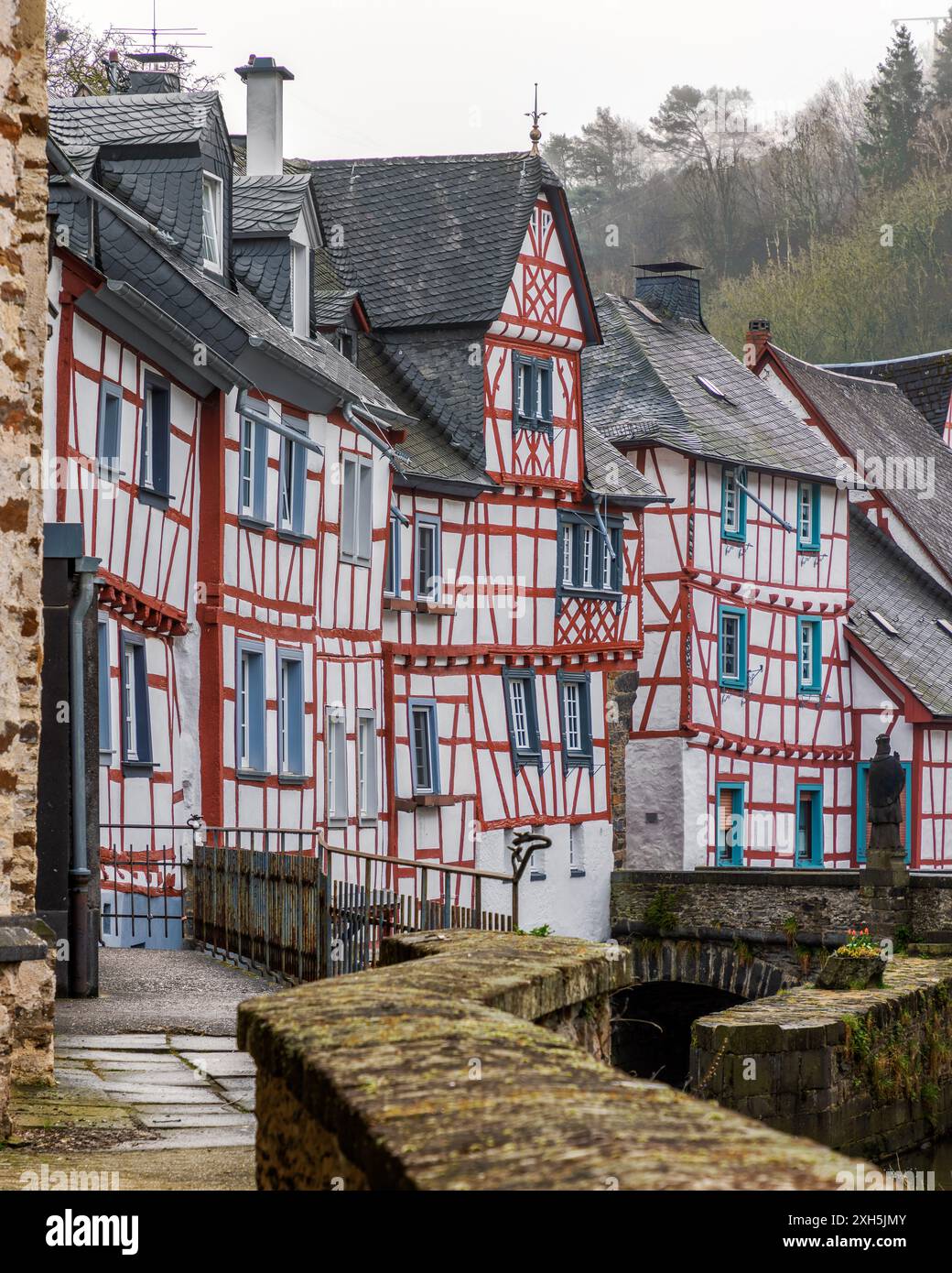 Charming half-timbered houses by a river with a medieval castle on a ...