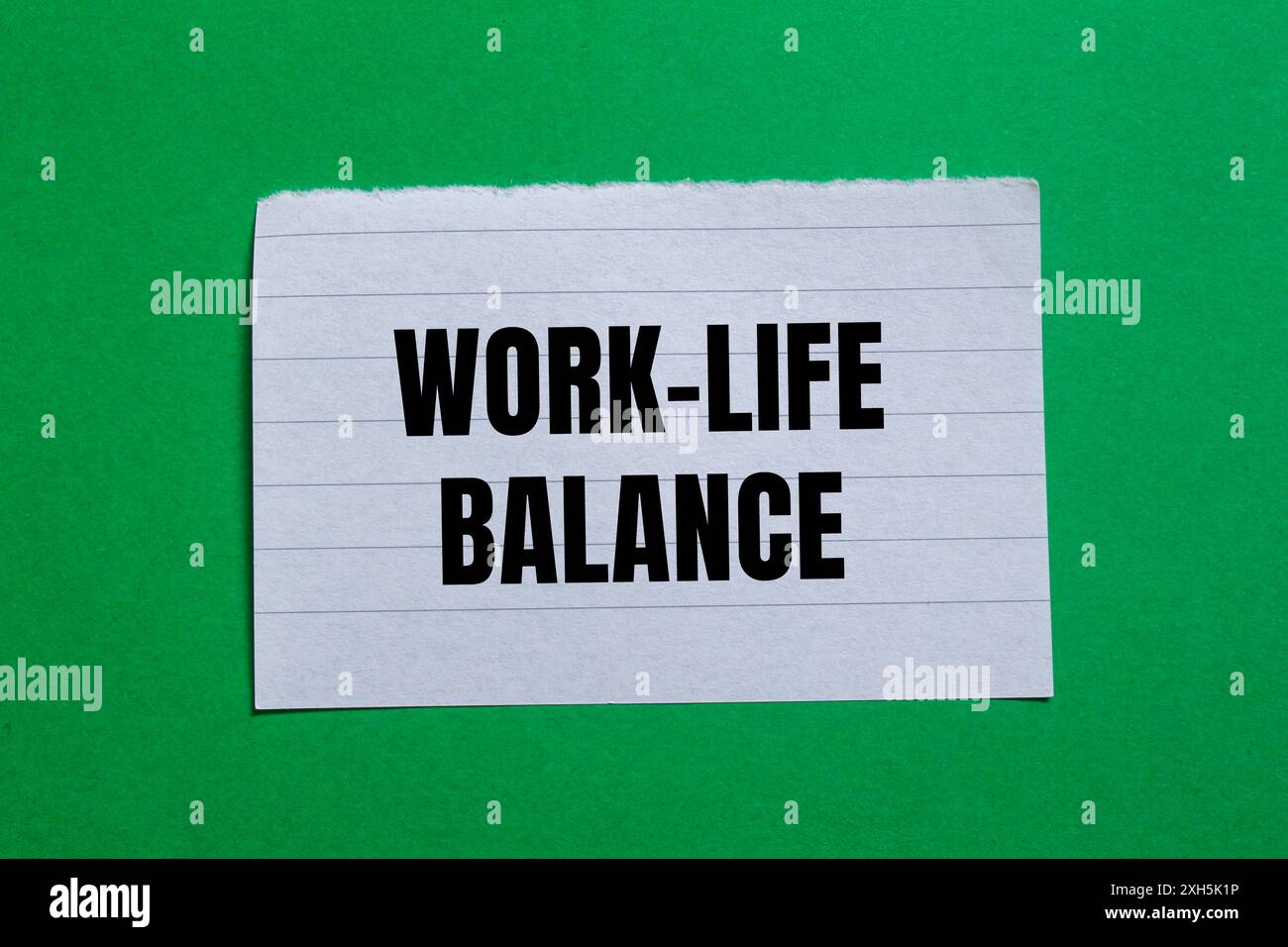Work life balance message written on ripped torn paper piece with green ...