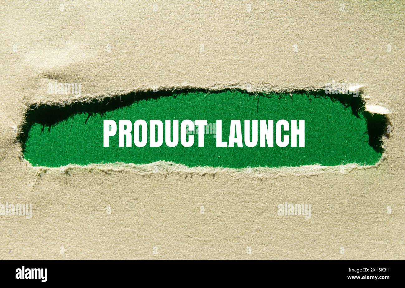 Product launch message written on ripped torn paper with green ...