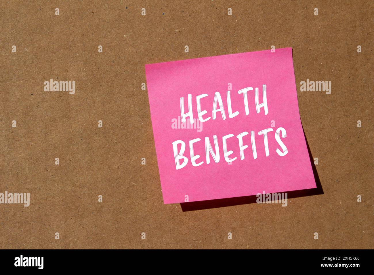 Health benefits message written on pink paper with cardboard background ...