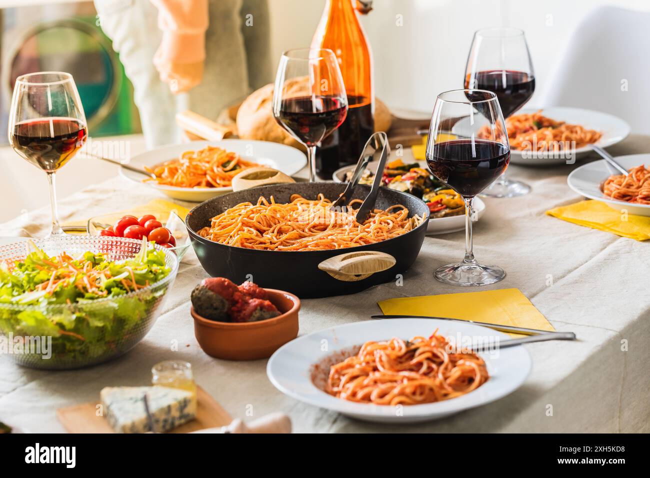 Family preparing a table for a traditional italian spaghetti dinner ...