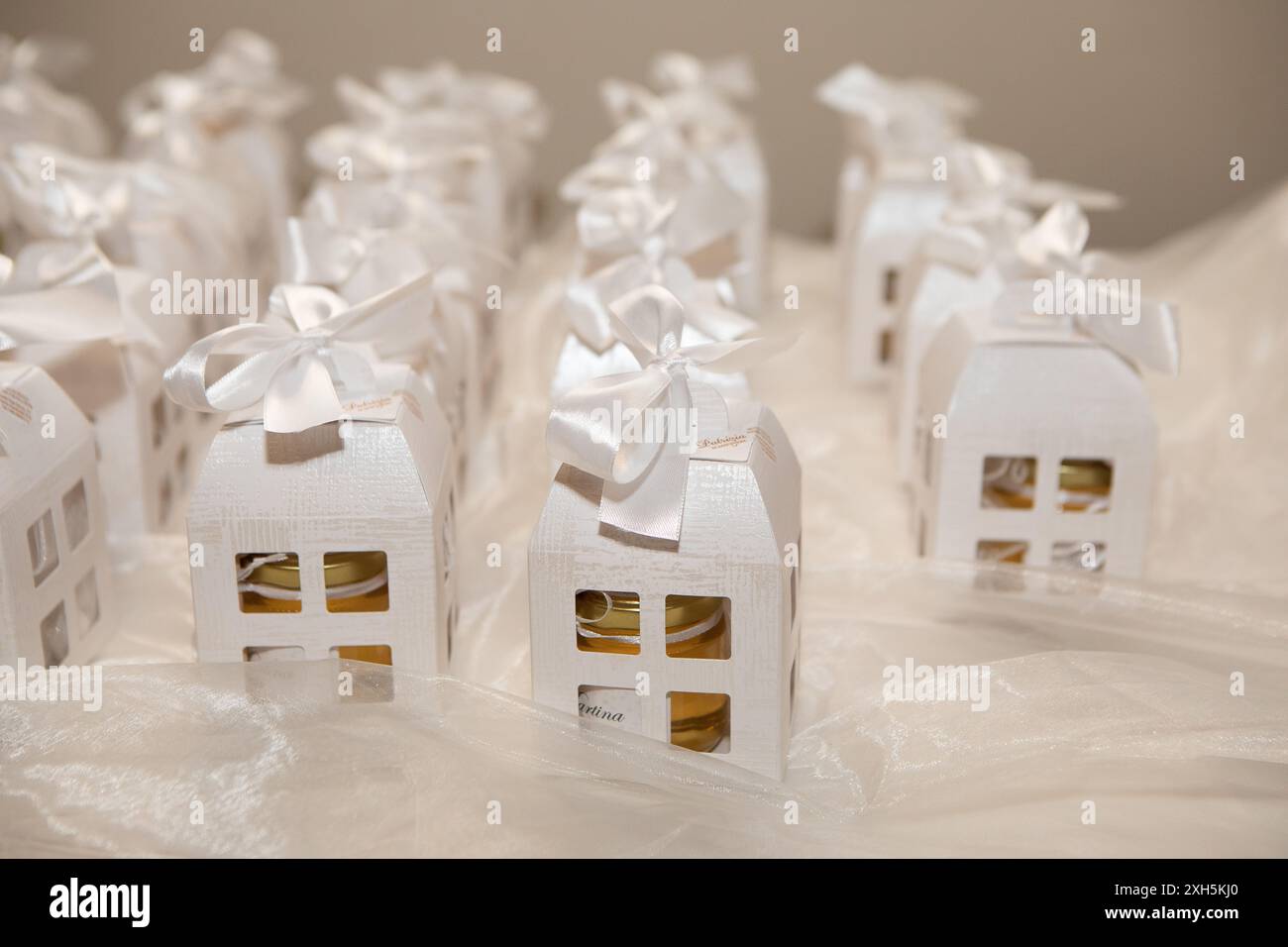 Many white cardboard boxes with satin ribbons are containing wedding ...