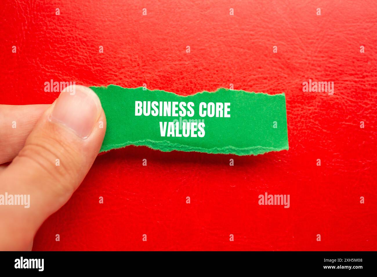 Business core values message written on ripped torn green paper with ...