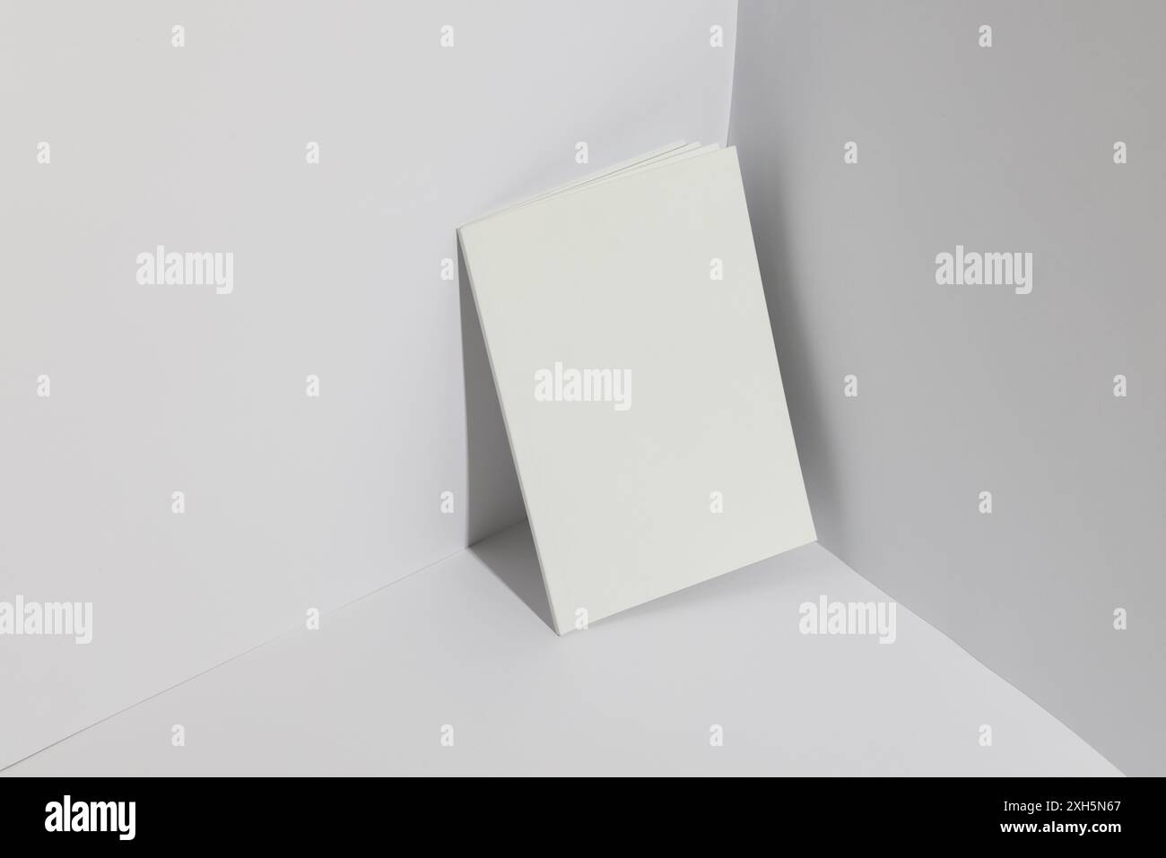 A blank book stands upright against a white background with copy space ...