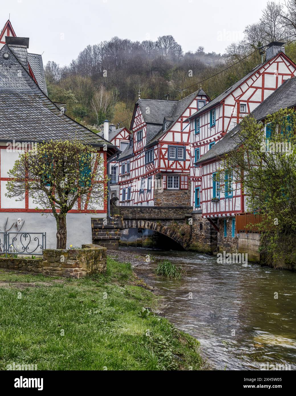 Charming half-timbered houses by a river with a medieval castle on a ...