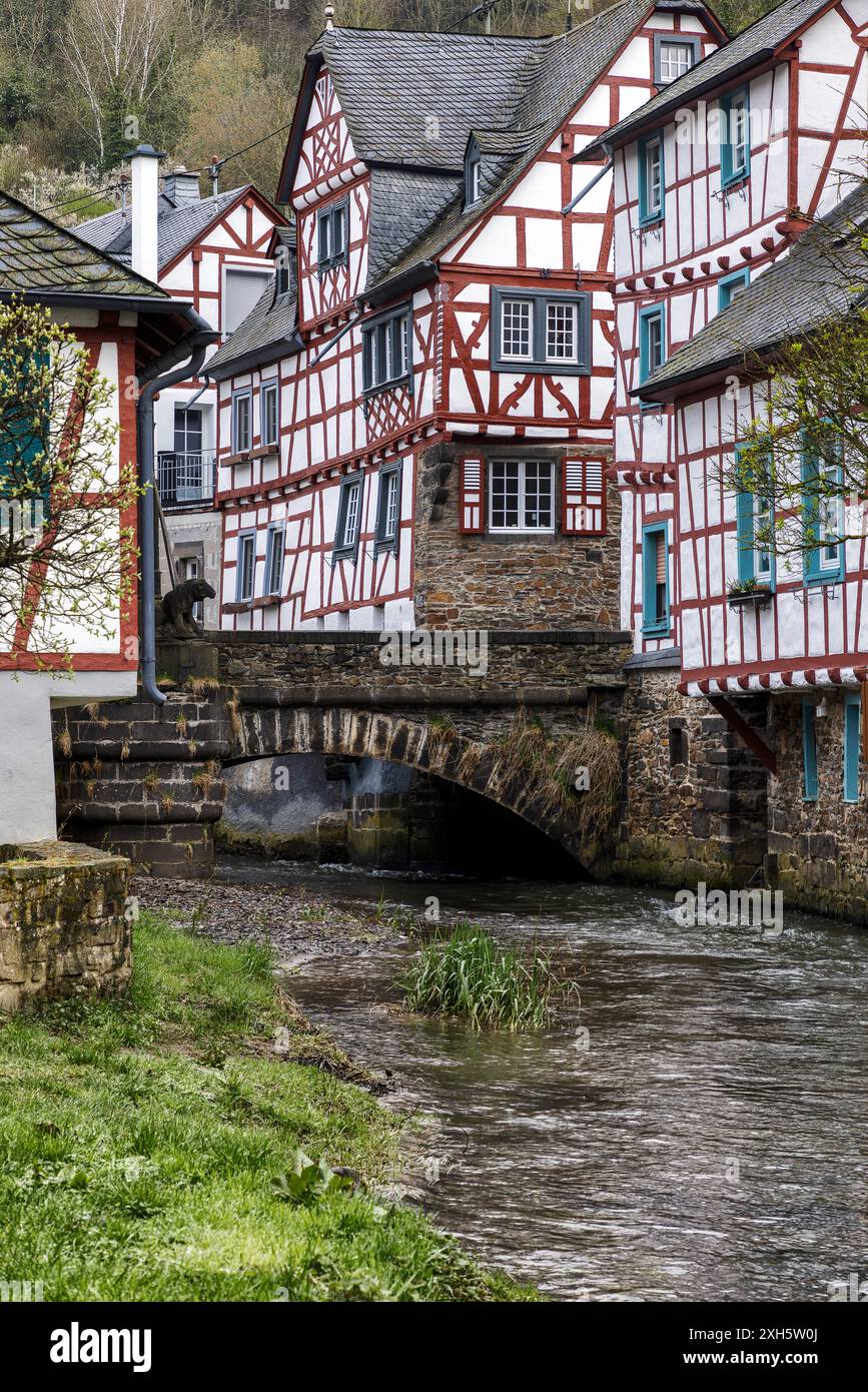 Charming half-timbered houses by a river with a medieval castle on a ...