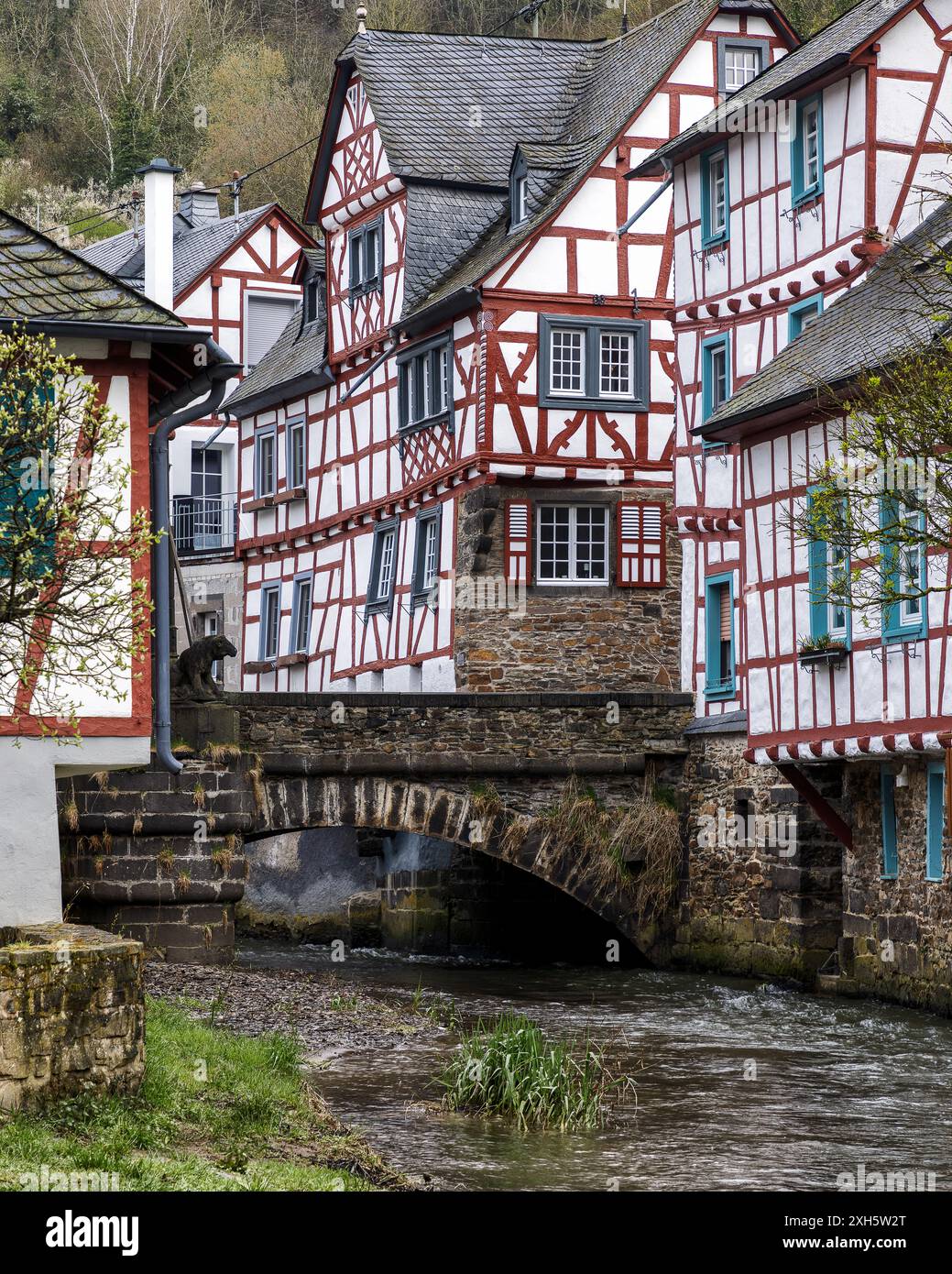 Charming half-timbered houses by a river with a medieval castle on a ...