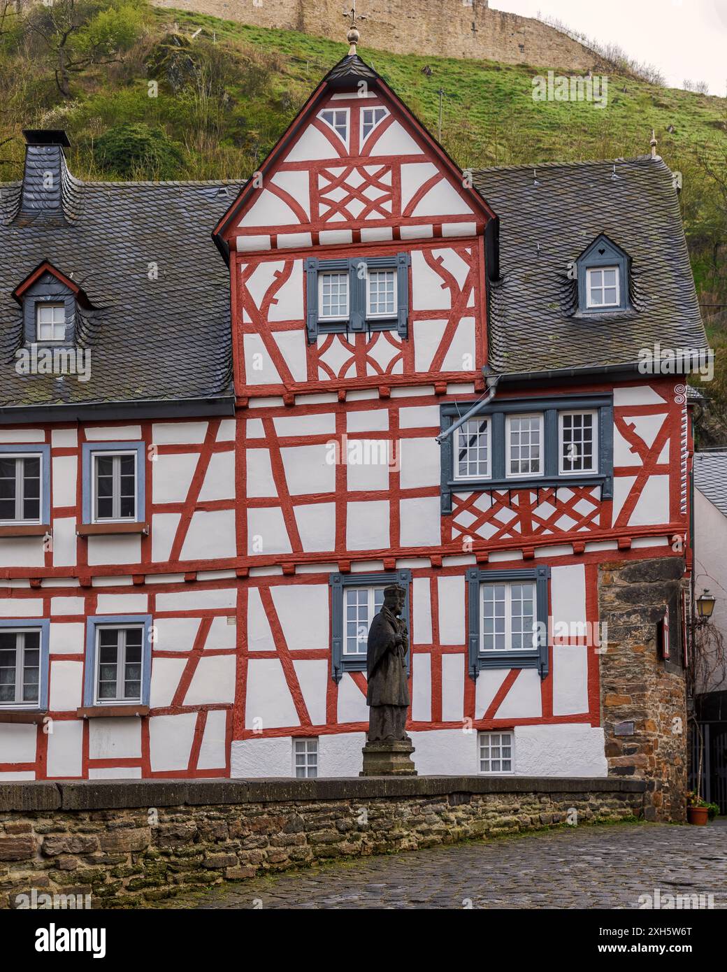 Charming half-timbered houses by a river with a medieval castle on a ...