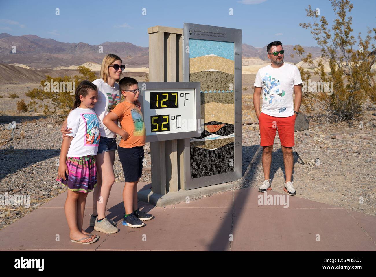 People pose with the thermometer at the Furnace Creek Visitor Center ...