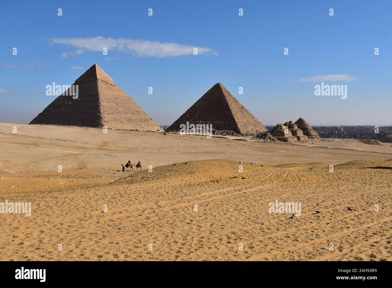 Pyramids of Giza under a Blue Sky with Riders in the Desert Stock Photo ...