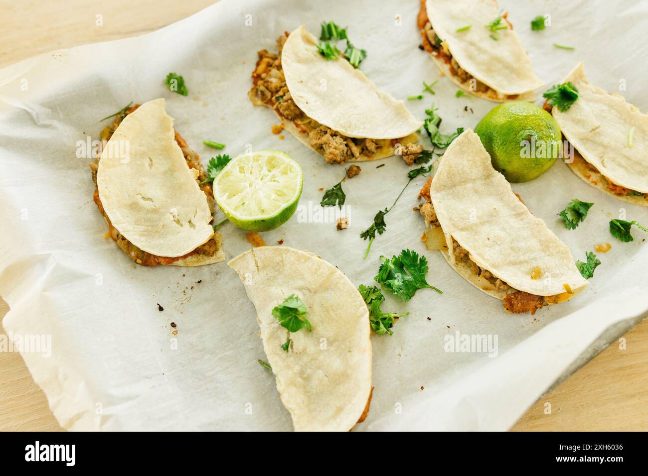 baked tacos on parchment paperwith lime and cilantro garnish Stock ...