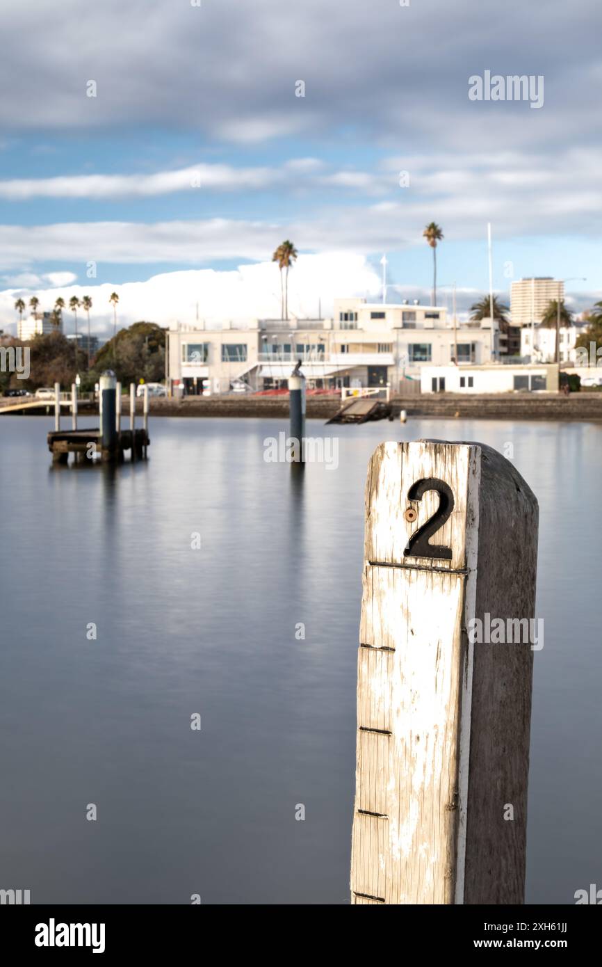 Wood tide height marker with calm water, Melbourne Stock Photo - Alamy