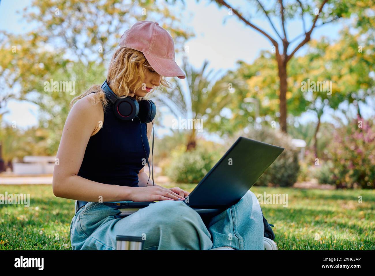 Student working on laptop in a campus park Stock Photo - Alamy