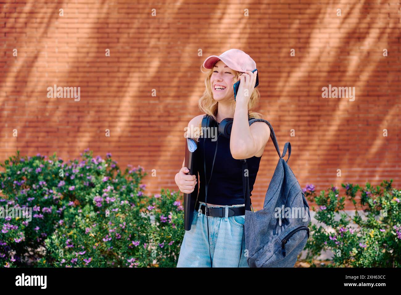 Student talking on phone outside building Stock Photo - Alamy