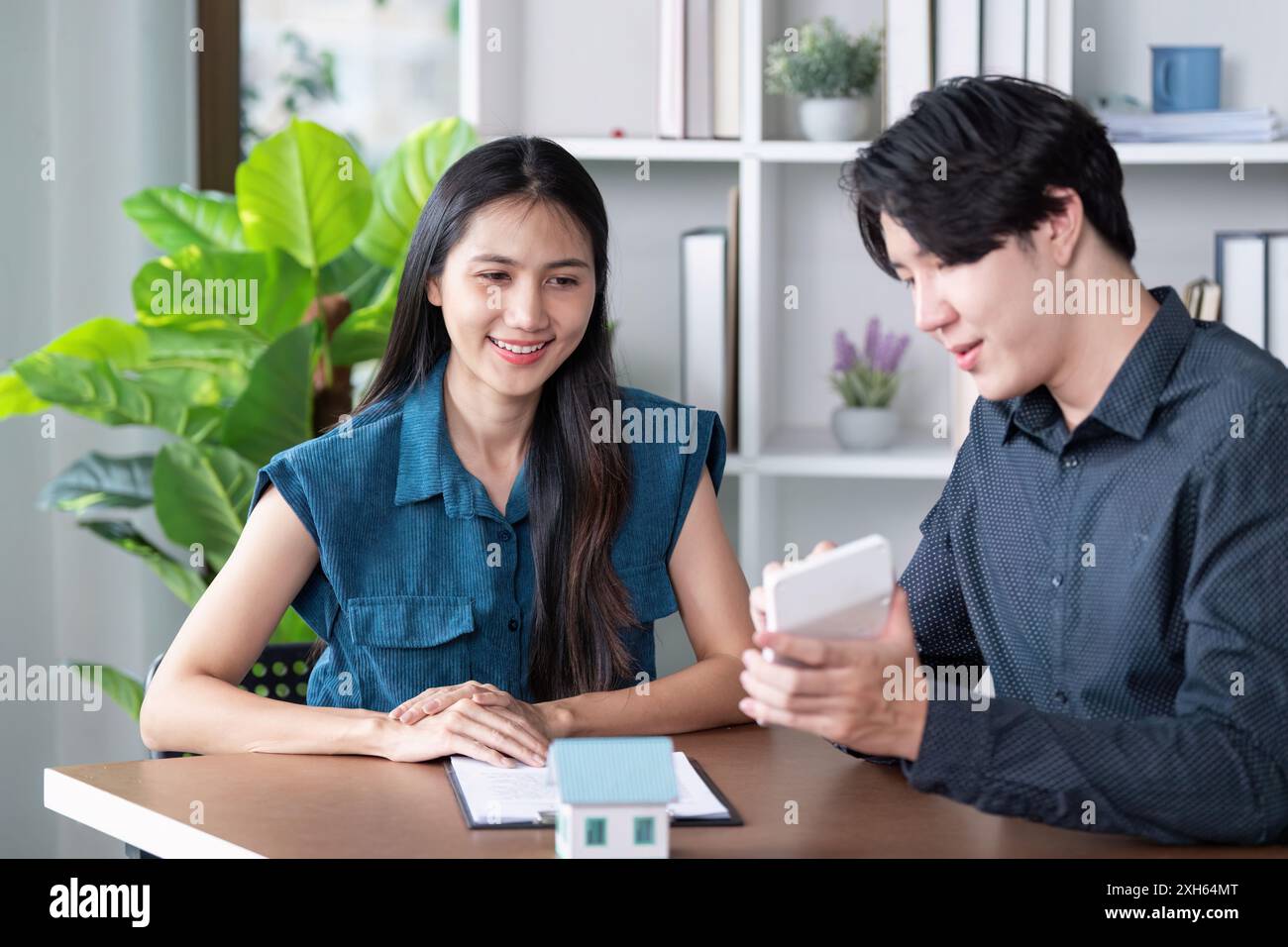 Real Estate Agent Showing Property Details to Potential Buy in Modern ...