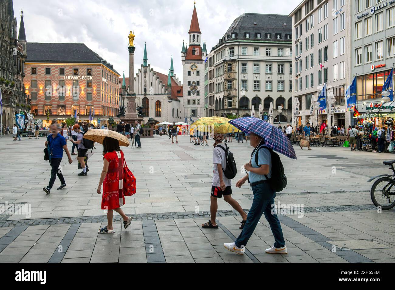 Touristen mit Regenschirmen am Marienplatz, München, Juli 2024 ...