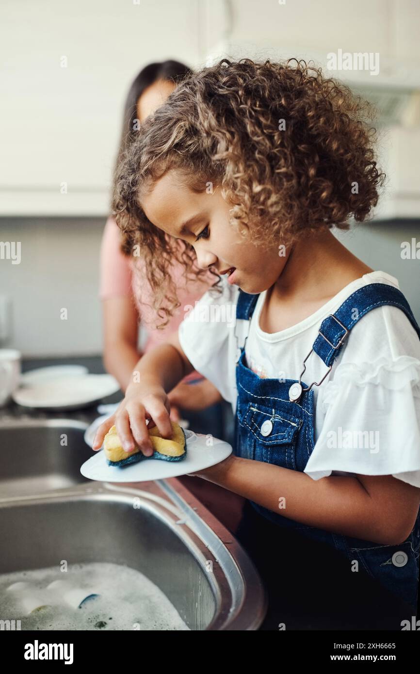 Girl, sponge and cleaning plates in kitchen, sanitary and prevent ...